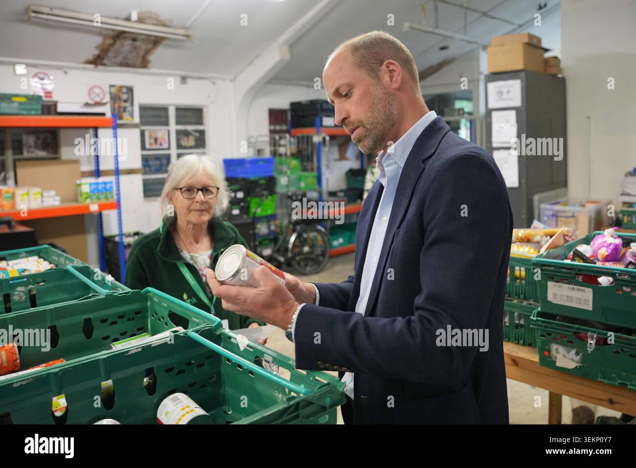 Britain's Prince William looks at food in the foodbank area as he ...