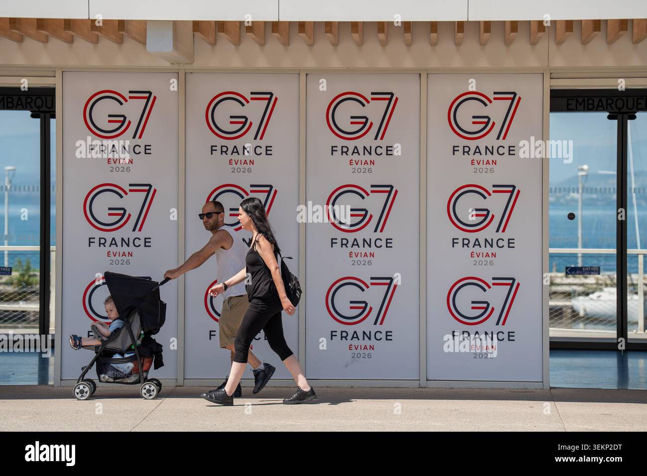 People walk past a G7 banner in Evian-les-Bains, eastern France ...