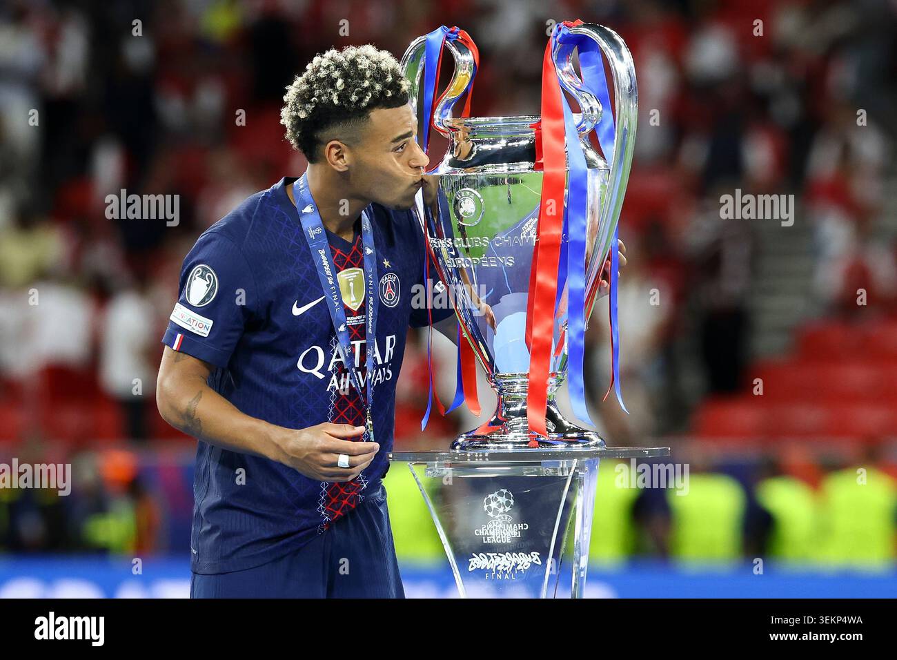 Desire Doue of Paris Saint-Germain kisses the trophy after the Paris ...