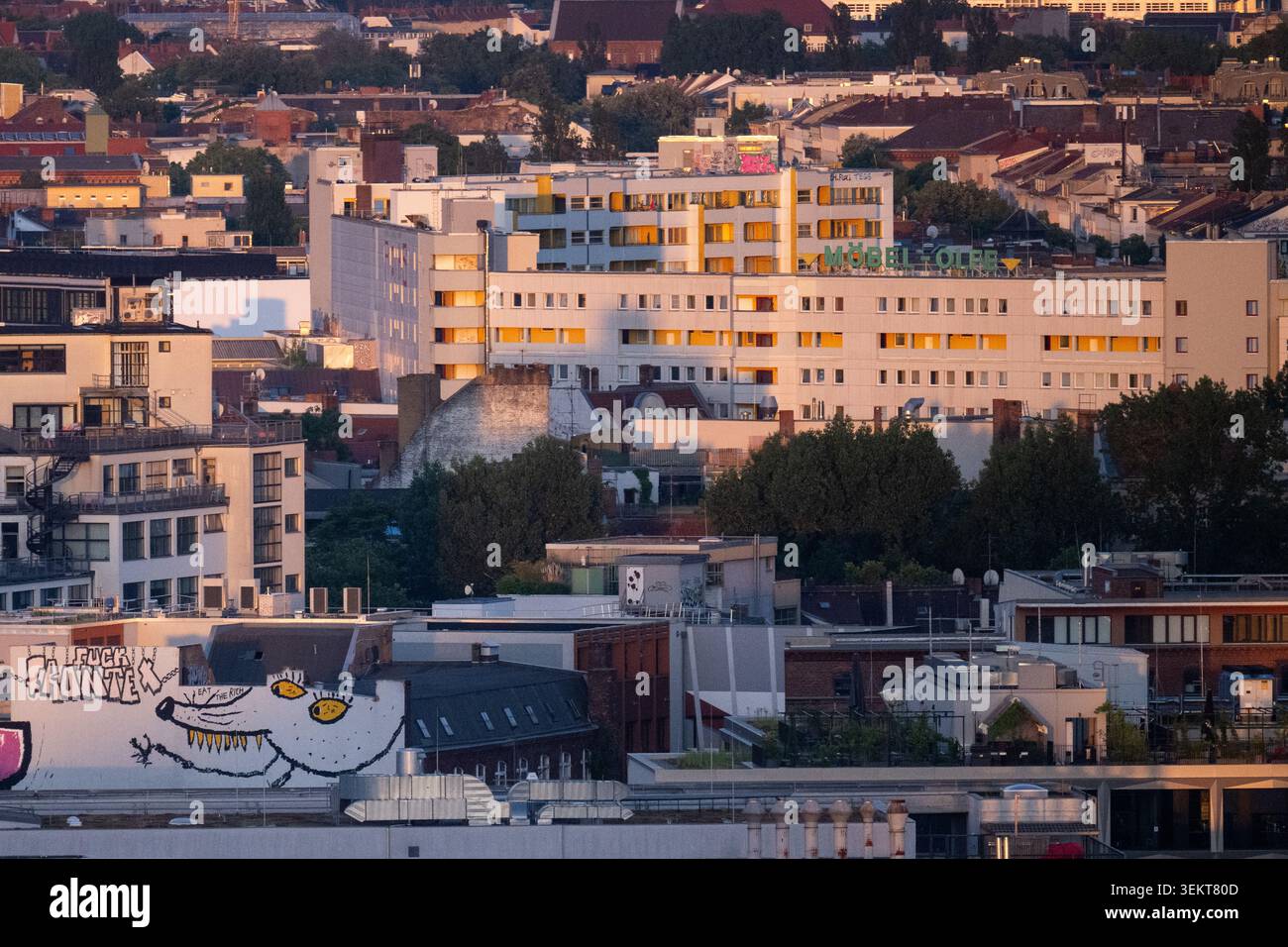 03 June 2026, Berlin: The light of the setting sun falls on apartment ...
