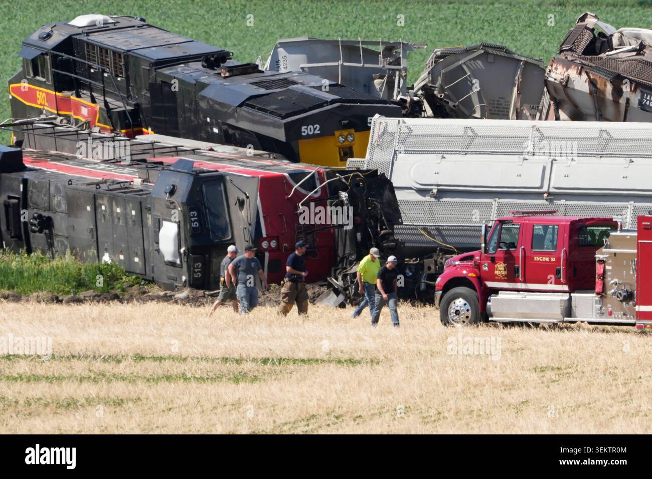 Workers and first responders walk past damage after a train derailed on ...