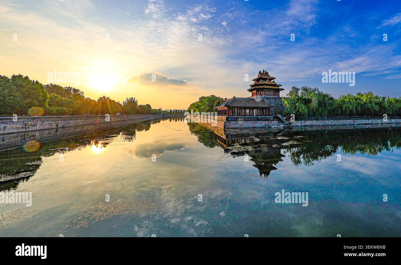 The morning glow tints the lake surface red at Beihai Park in Beijing ...