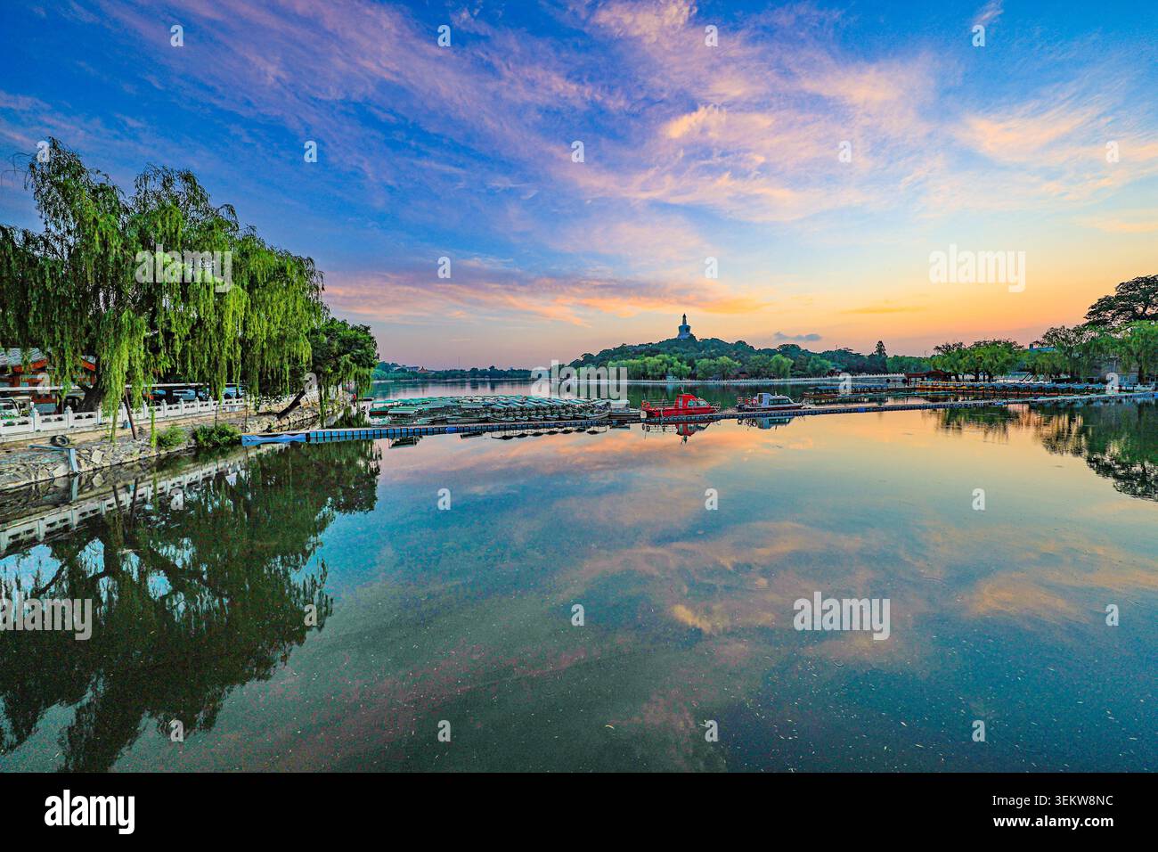 The morning glow tints the lake surface red at Beihai Park in Beijing ...