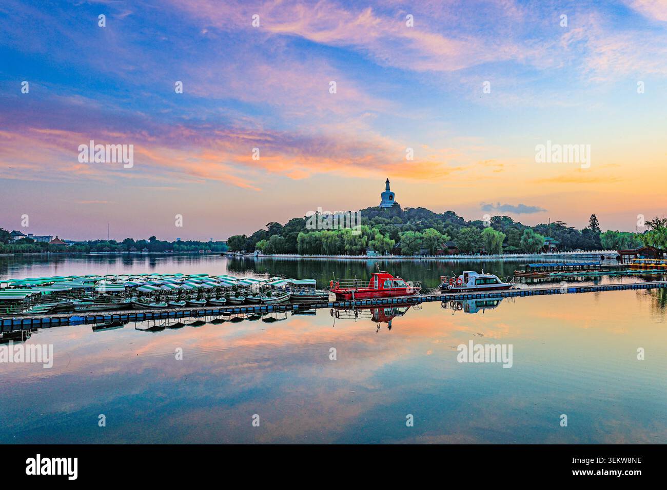 The morning glow tints the lake surface red at Beihai Park in Beijing ...