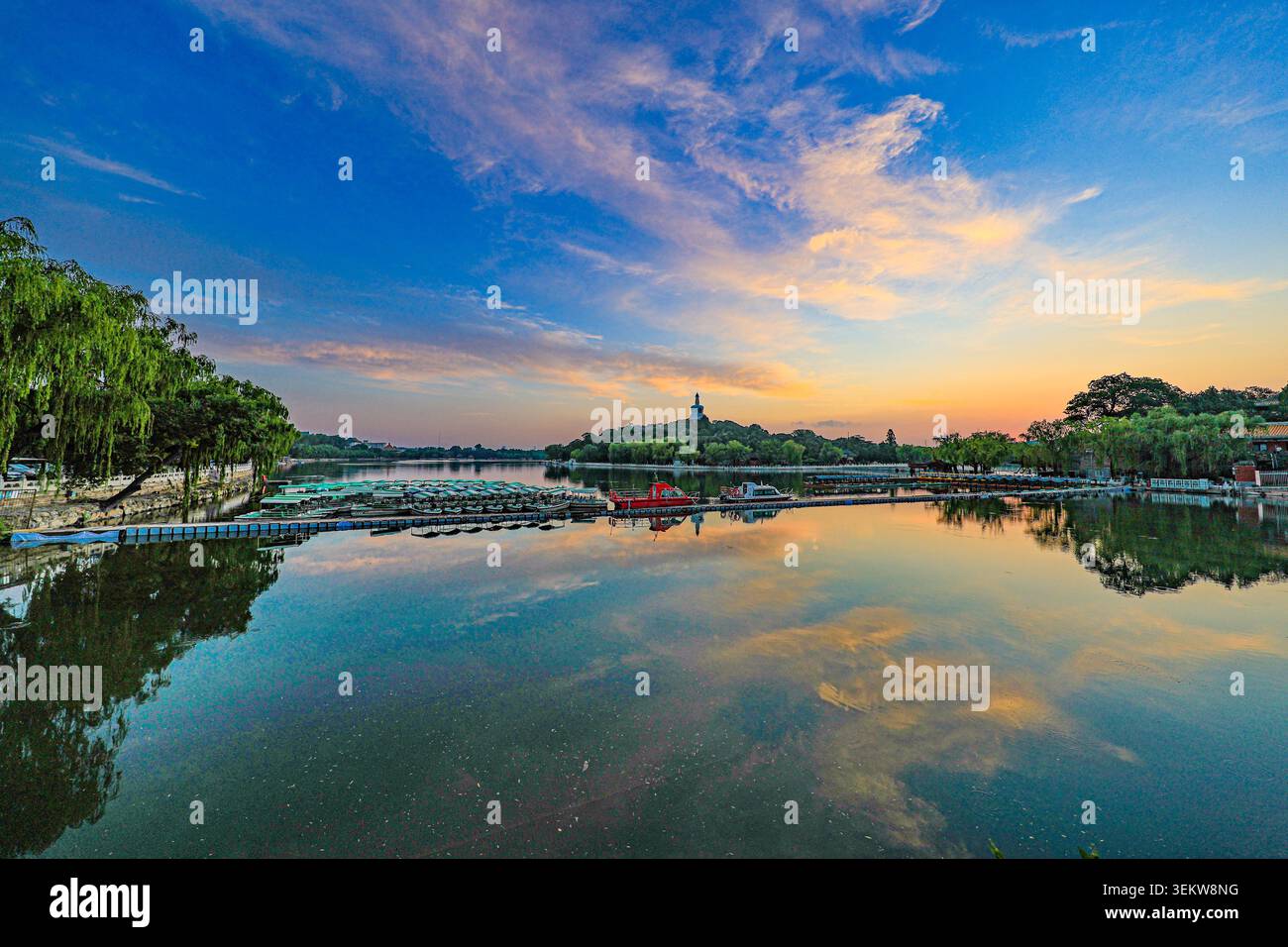 The morning glow tints the lake surface red at Beihai Park in Beijing ...