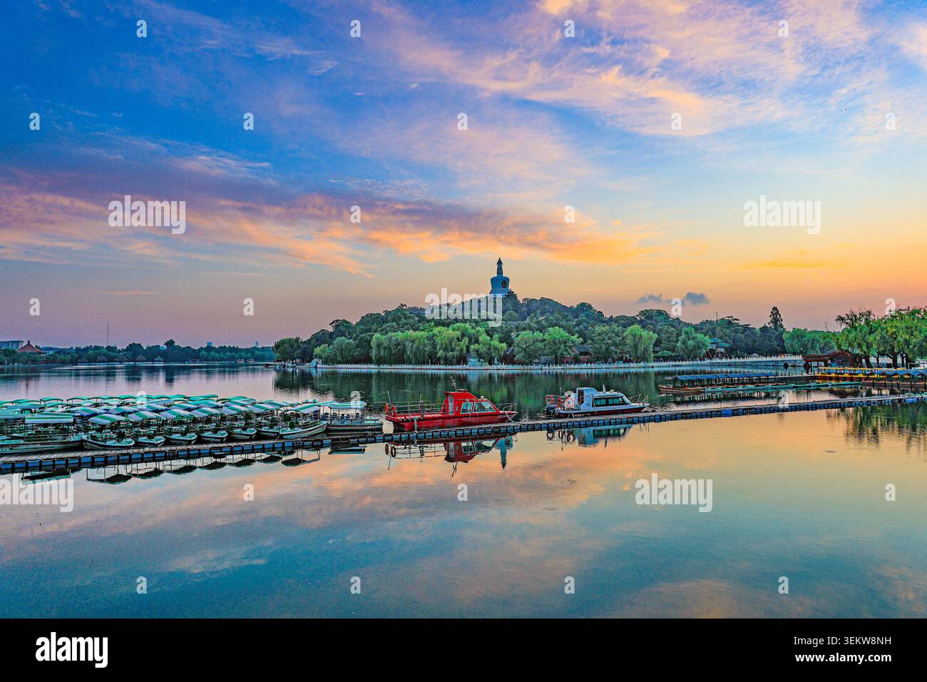 The morning glow tints the lake surface red at Beihai Park in Beijing ...