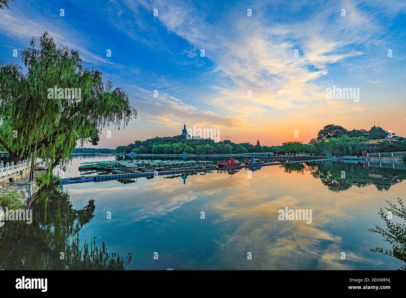 The morning glow tints the lake surface red at Beihai Park in Beijing ...