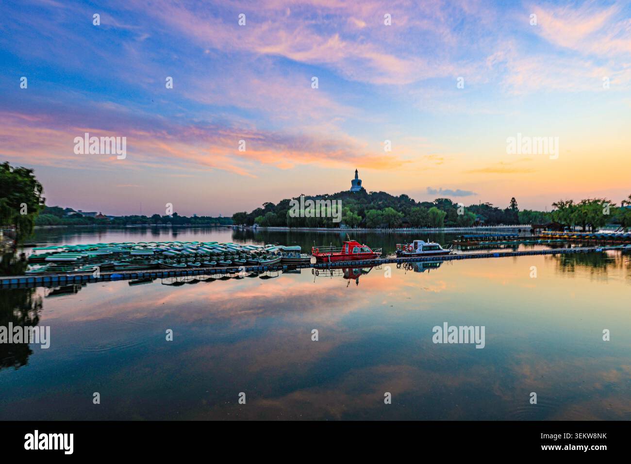 The morning glow tints the lake surface red at Beihai Park in Beijing ...