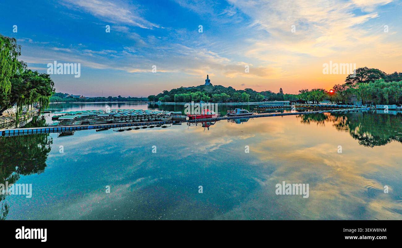 The morning glow tints the lake surface red at Beihai Park in Beijing ...
