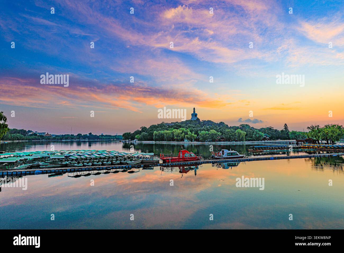 The morning glow tints the lake surface red at Beihai Park in Beijing ...