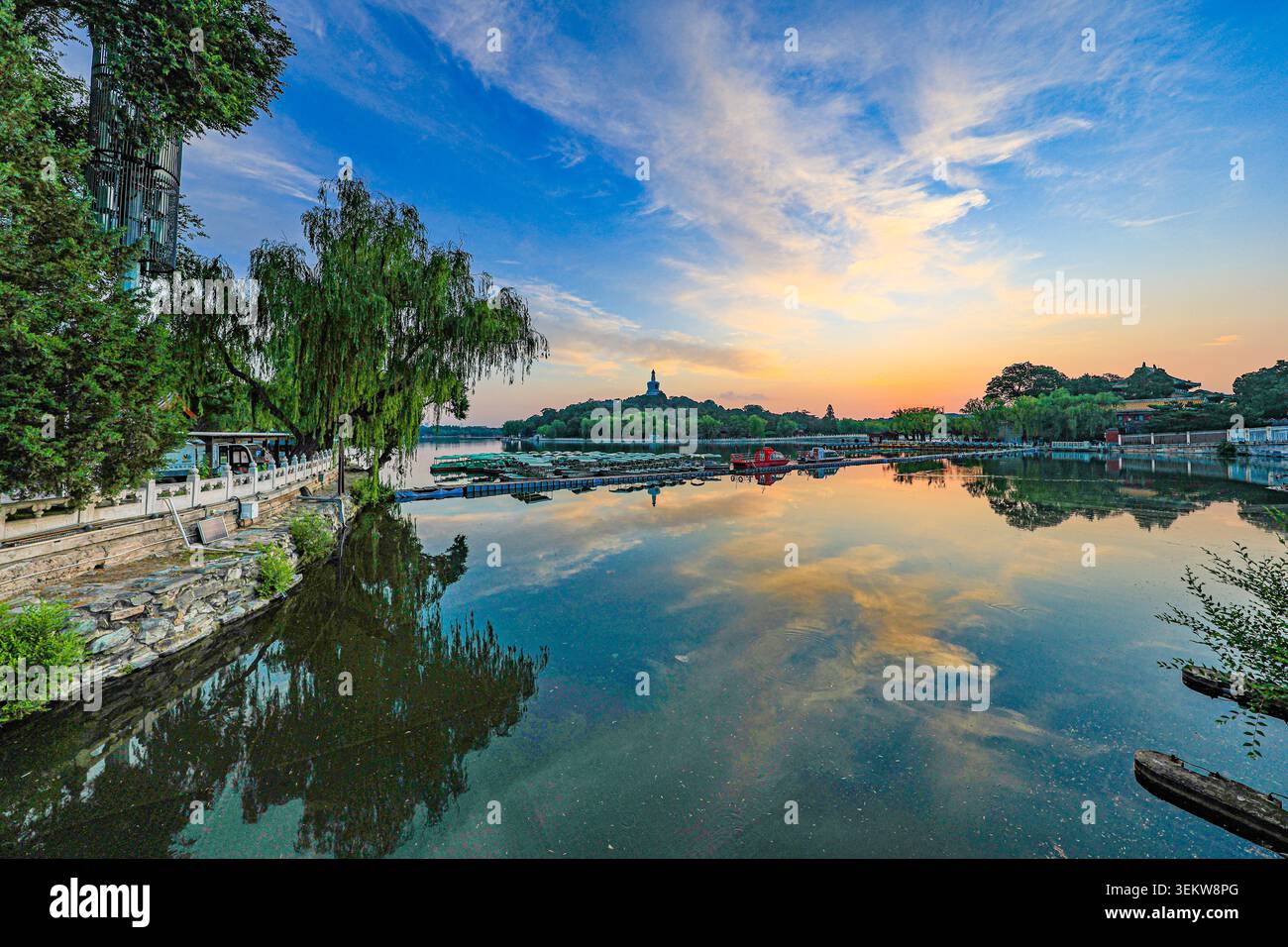 The morning glow tints the lake surface red at Beihai Park in Beijing ...