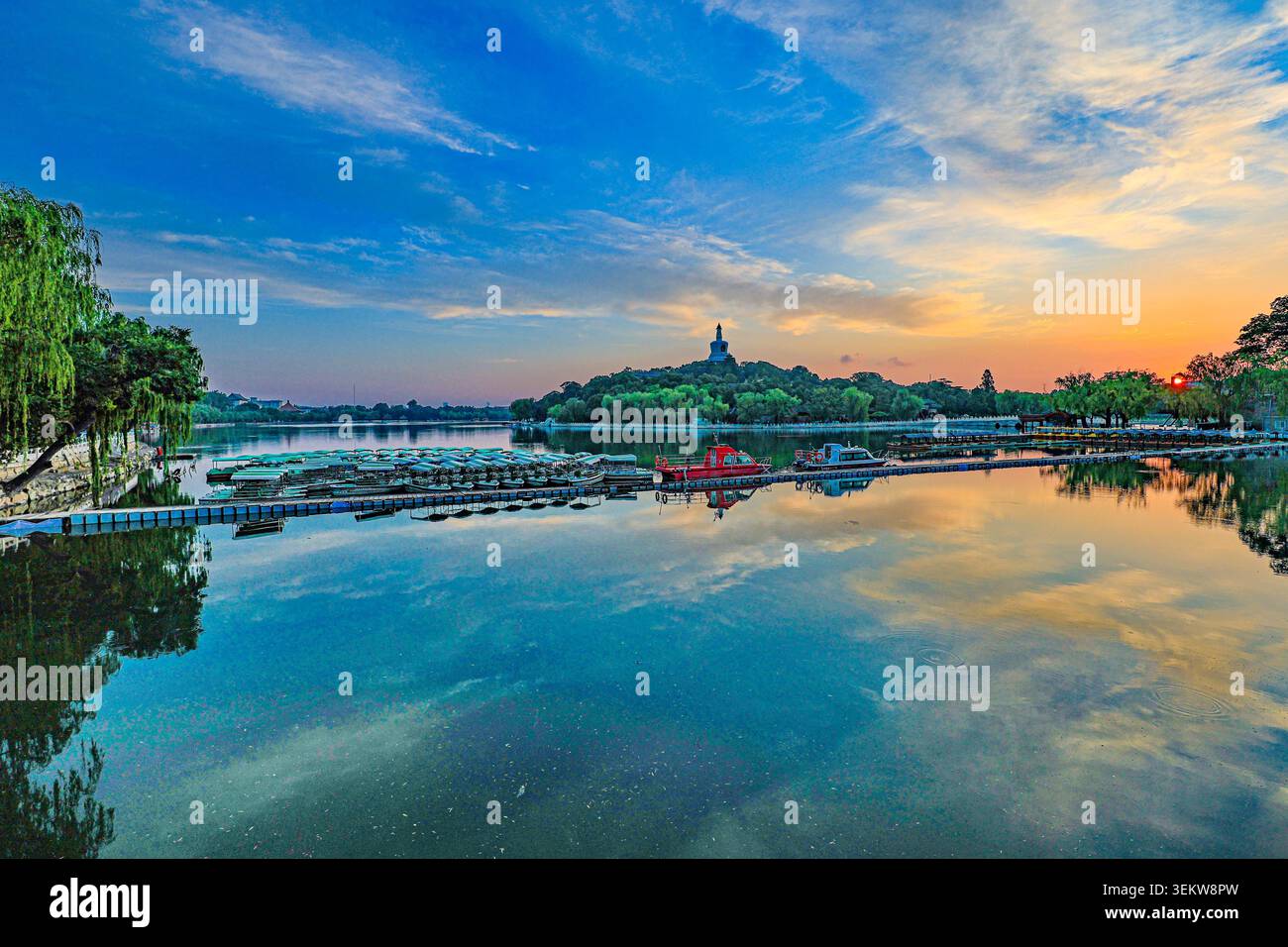 The morning glow tints the lake surface red at Beihai Park in Beijing ...