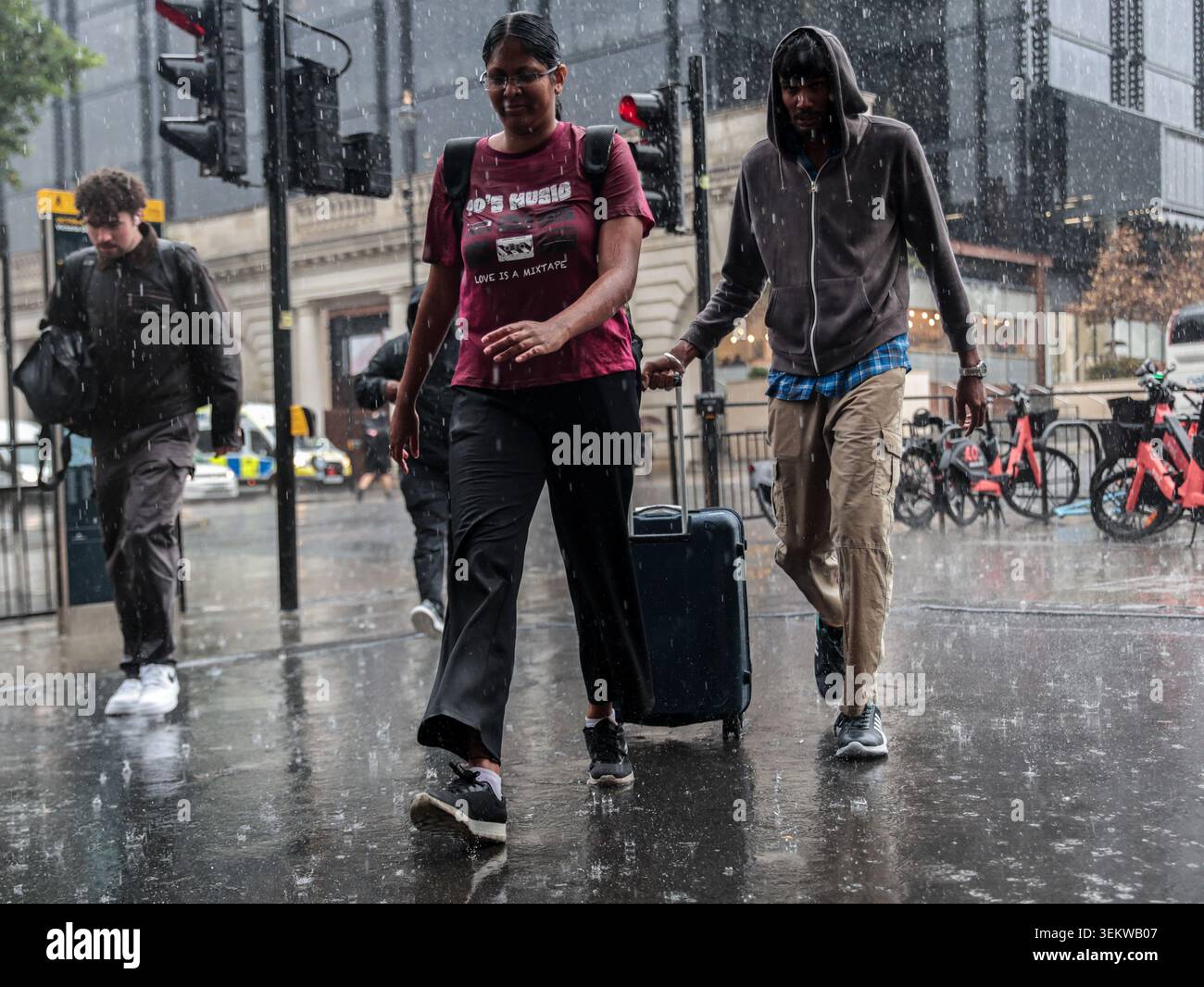 People seen walking in rain and tander storm disrupted commute. (Photo ...