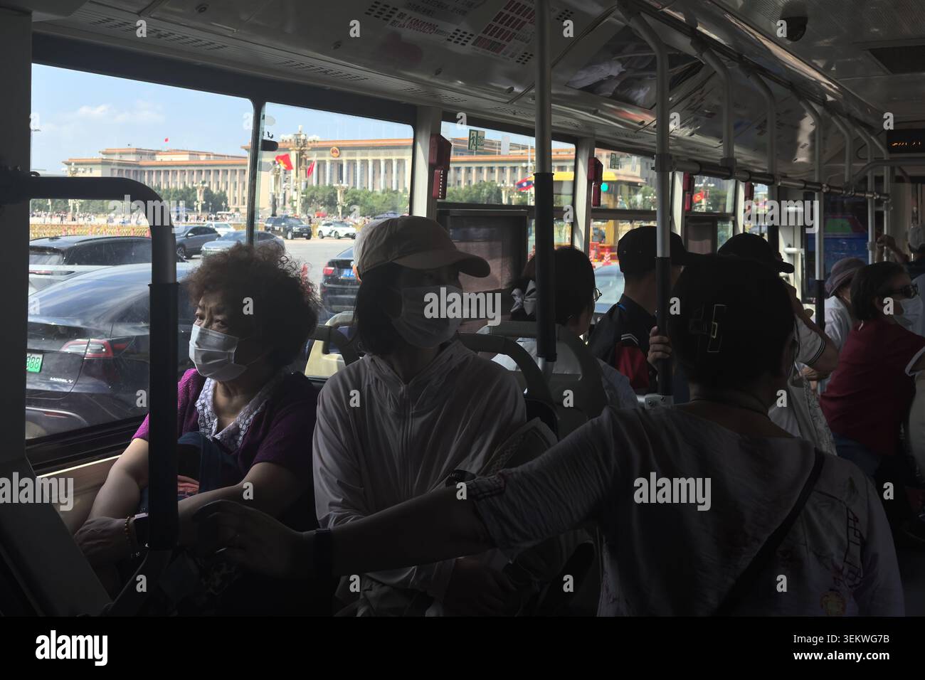Commuters ride on the bus traveling past the Tiananmen Square in ...