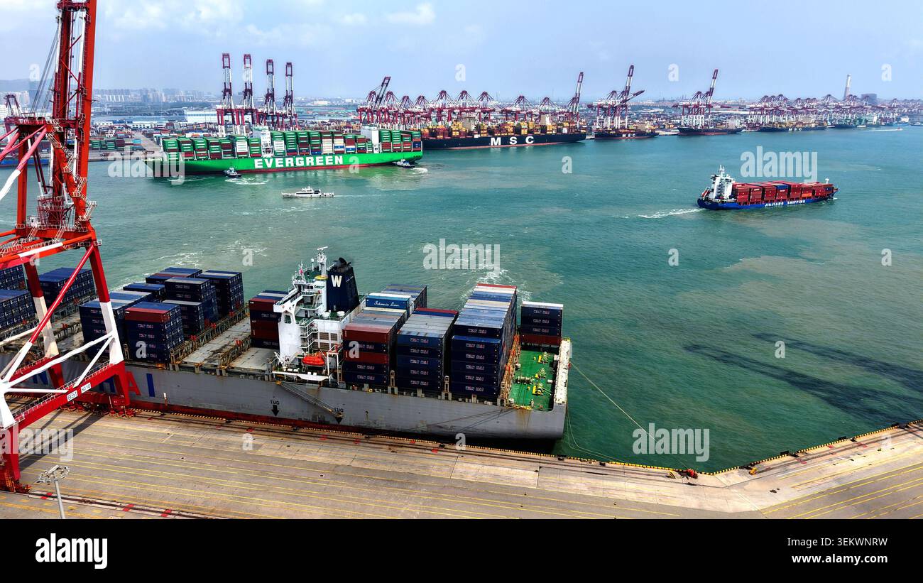A cargo ship loaded with foreign trade containers docks at Qingdao Port ...