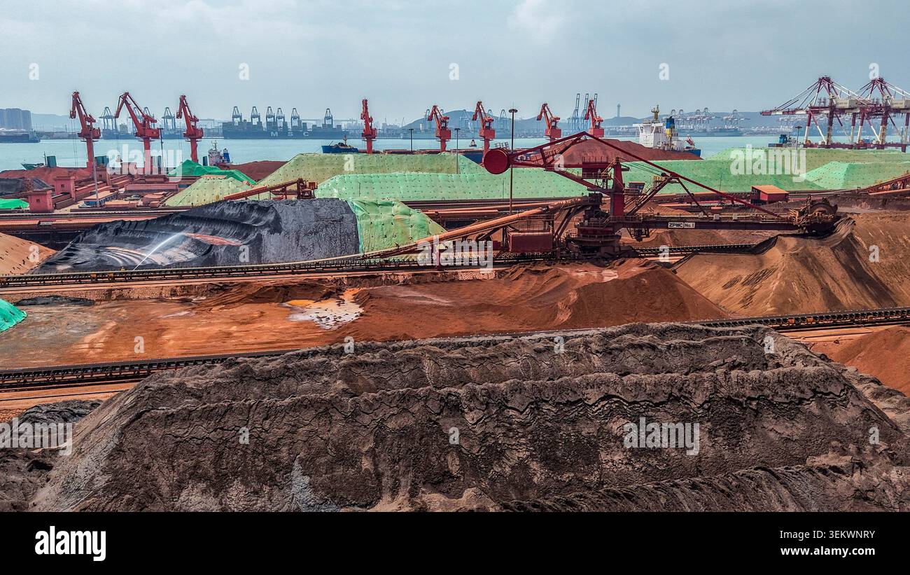 Engineering vehicles operate at the iron ore terminal of Qingdao Port ...