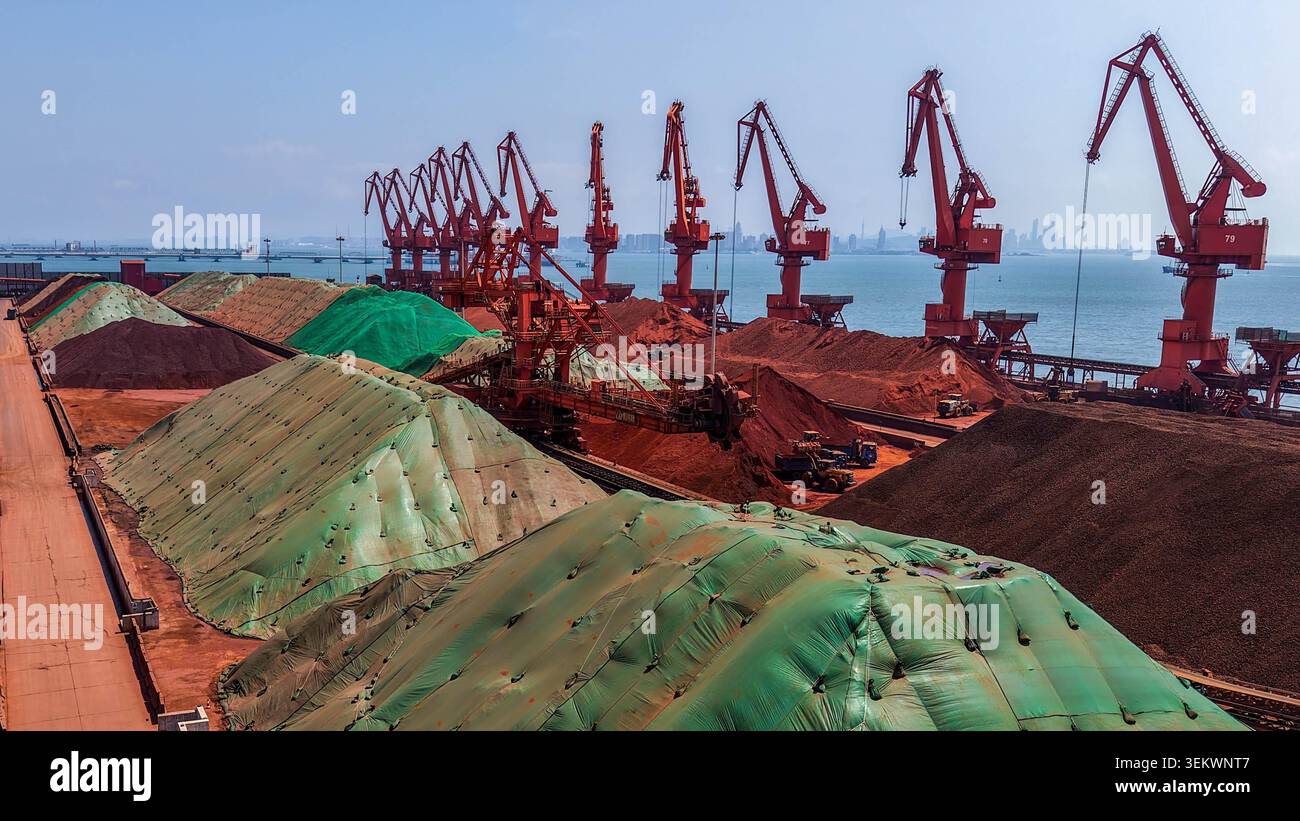 Engineering vehicles operate at the iron ore terminal of Qingdao Port ...