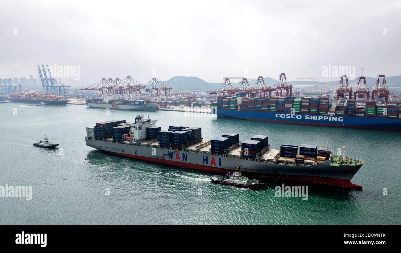 A cargo ship loaded with foreign trade containers docks at Qingdao Port ...