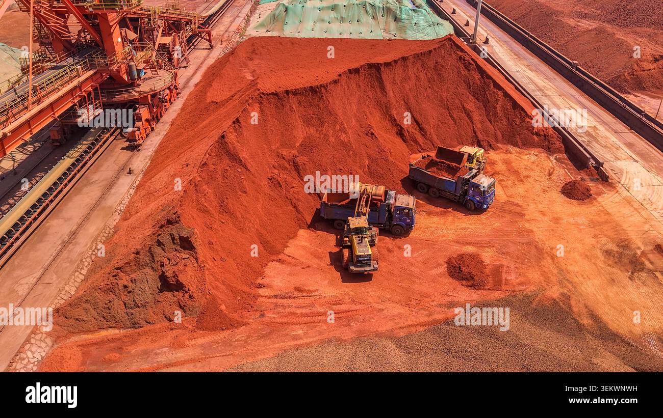 Engineering vehicles operate at the iron ore terminal of Qingdao Port ...