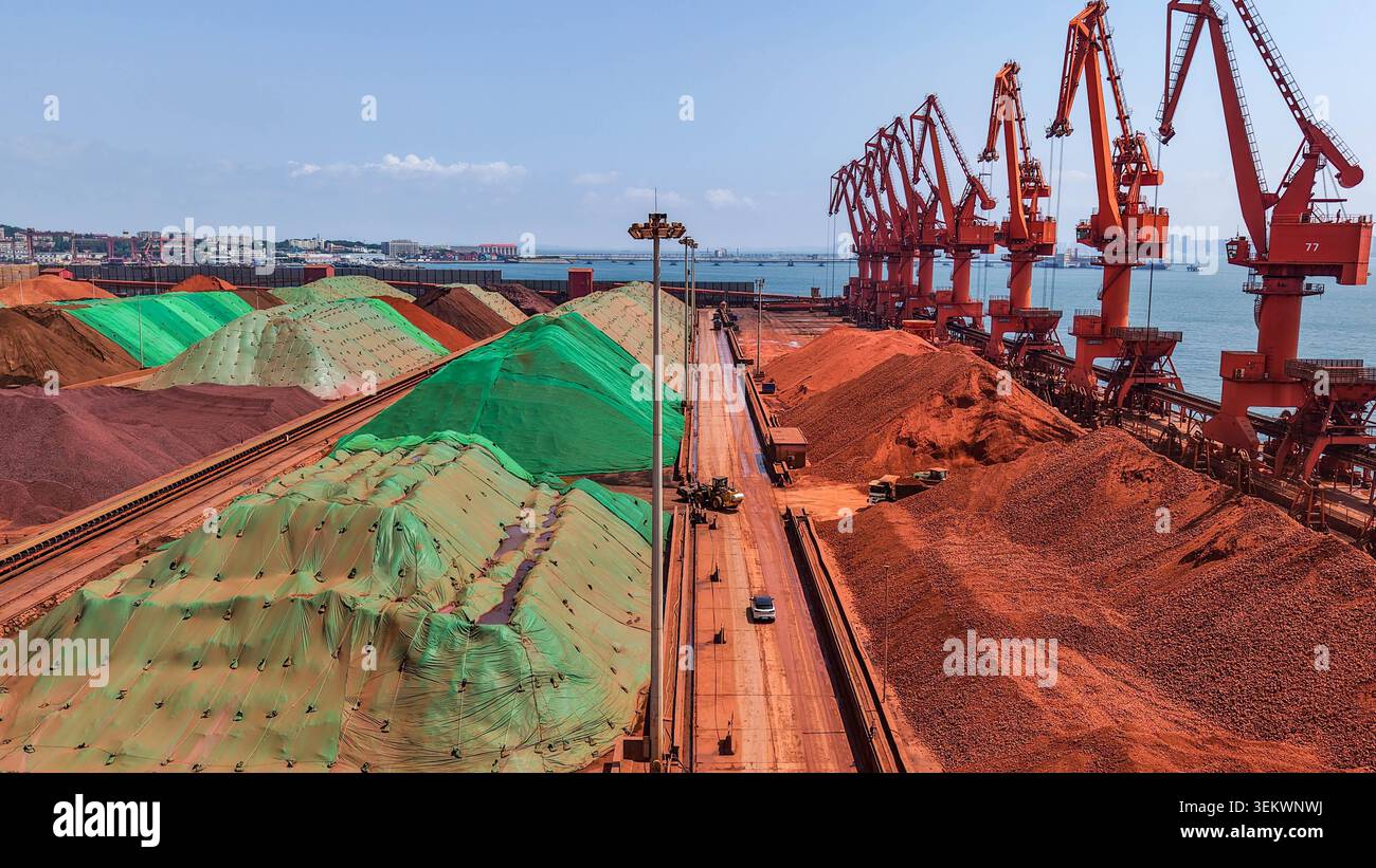 Engineering vehicles operate at the iron ore terminal of Qingdao Port ...