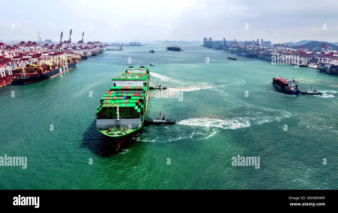 A cargo ship loaded with foreign trade containers docks at Qingdao Port ...