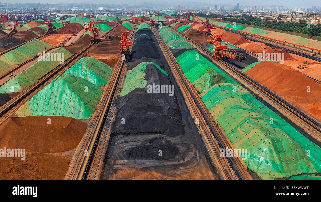 Engineering vehicles operate at the iron ore terminal of Qingdao Port ...