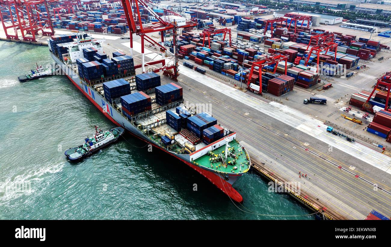 A cargo ship loaded with foreign trade containers docks at Qingdao Port ...