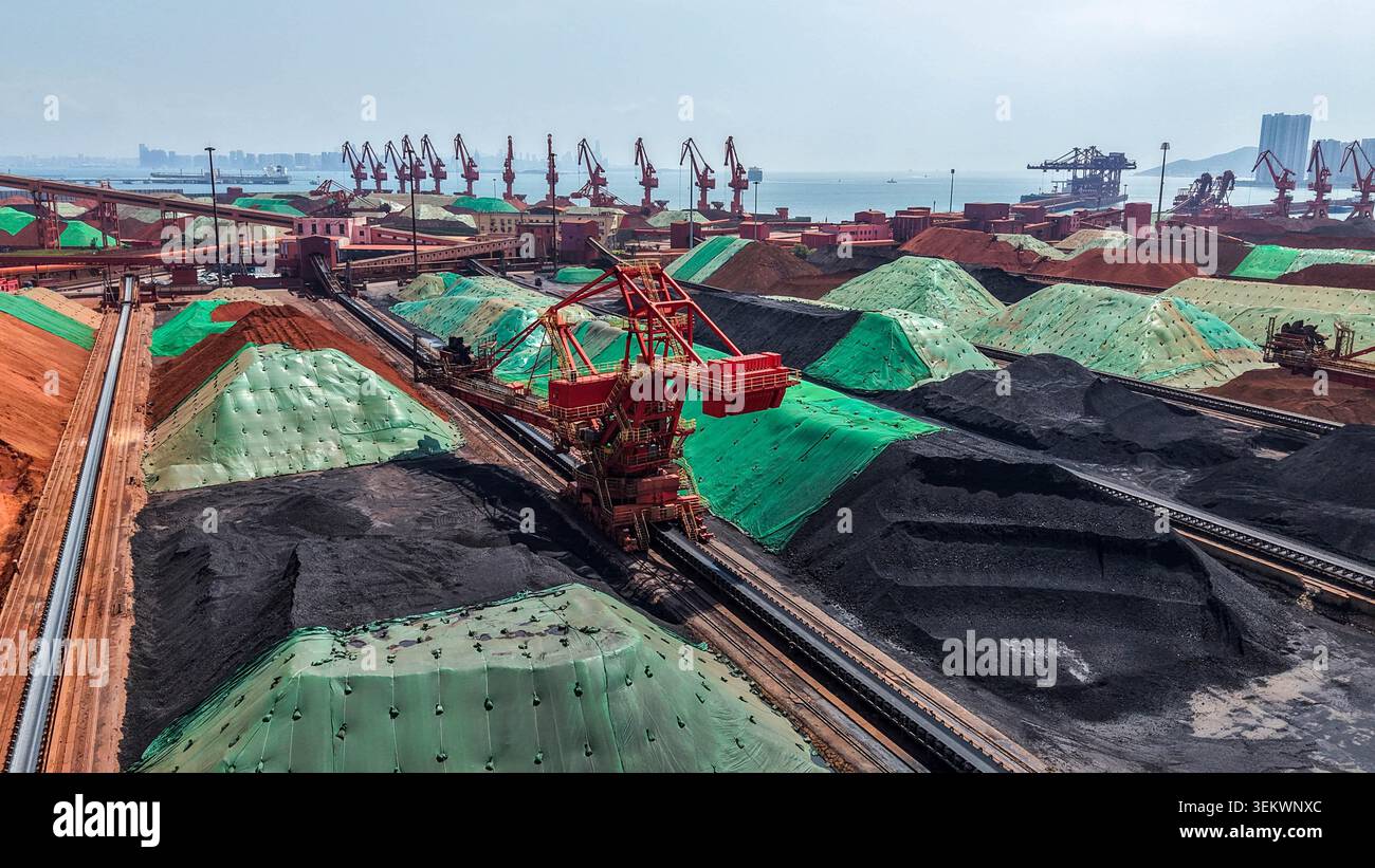 Engineering vehicles operate at the iron ore terminal of Qingdao Port ...