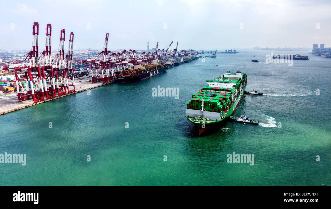 A cargo ship loaded with foreign trade containers docks at Qingdao Port ...