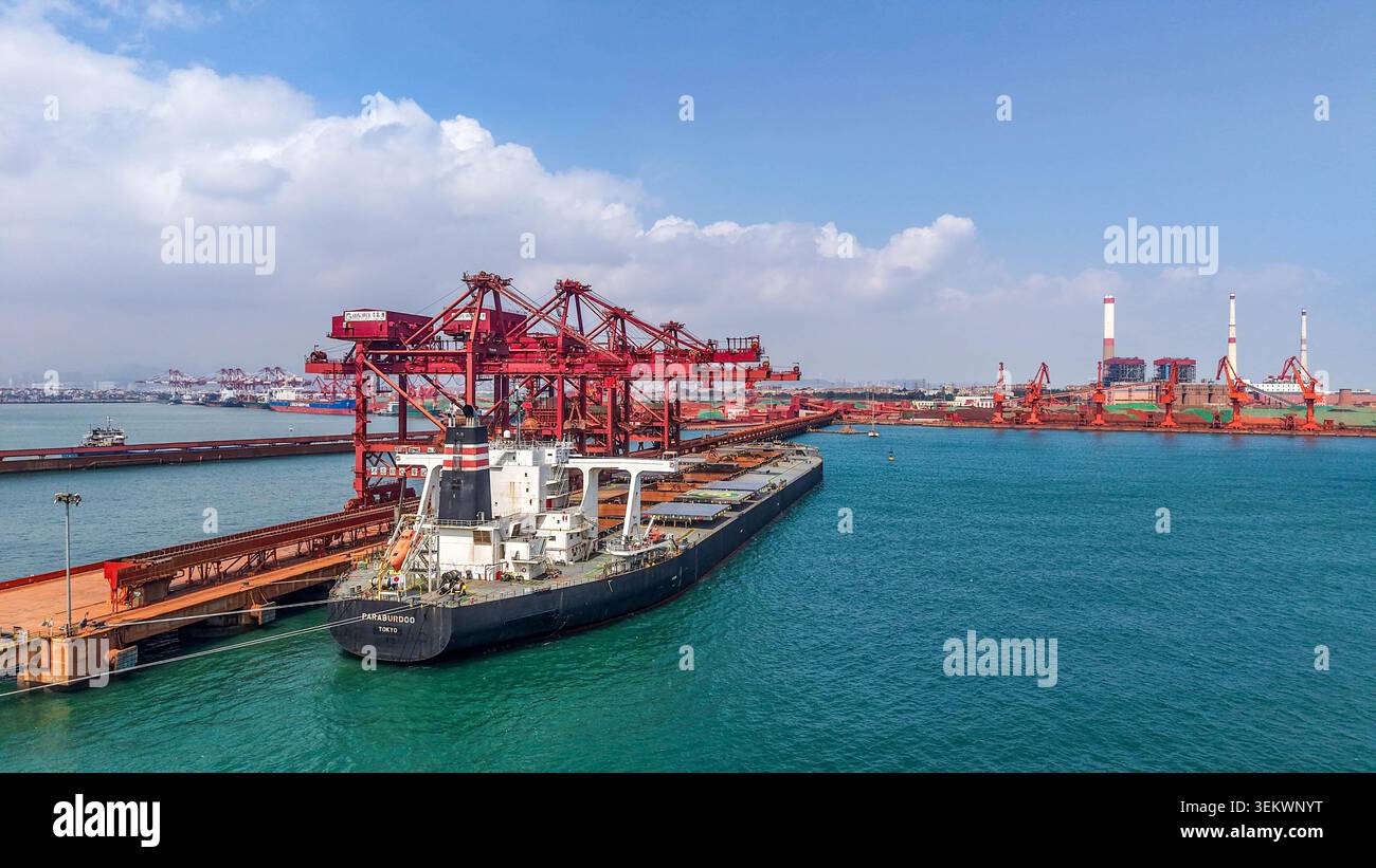 Engineering vehicles operate at the iron ore terminal of Qingdao Port ...