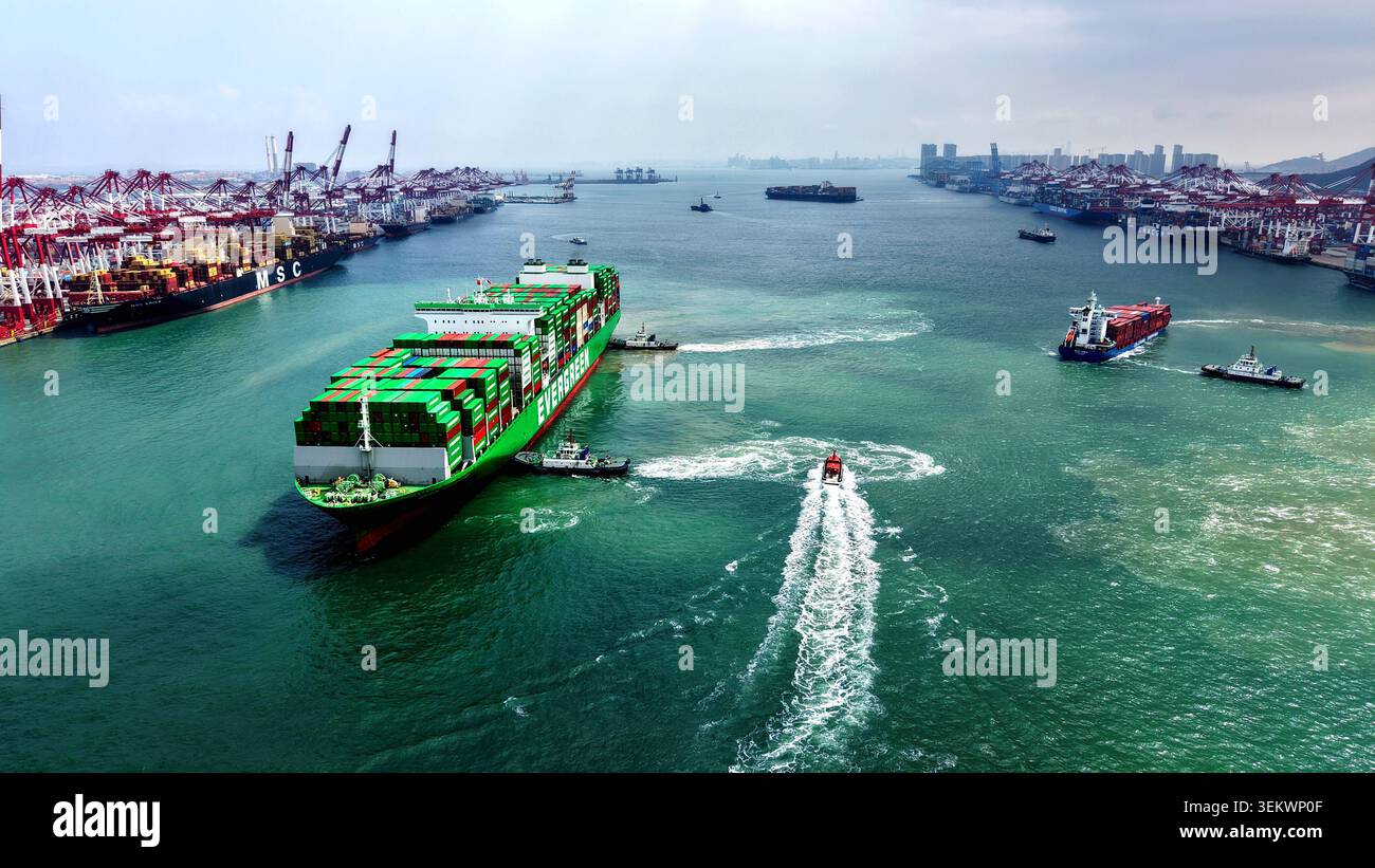 A cargo ship loaded with foreign trade containers docks at Qingdao Port ...