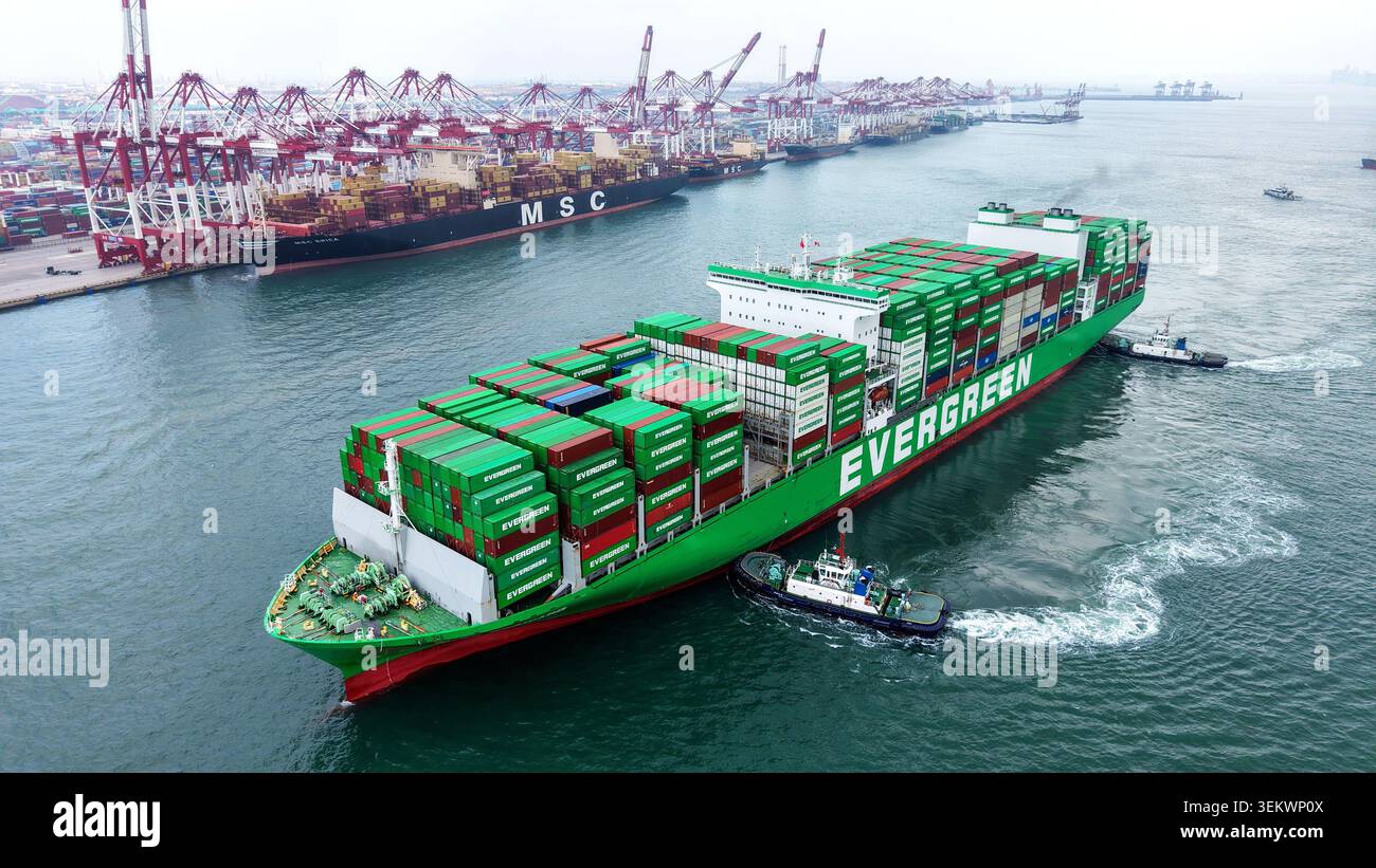 A cargo ship loaded with foreign trade containers docks at Qingdao Port ...
