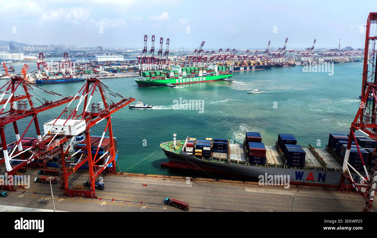 A cargo ship loaded with foreign trade containers docks at Qingdao Port ...