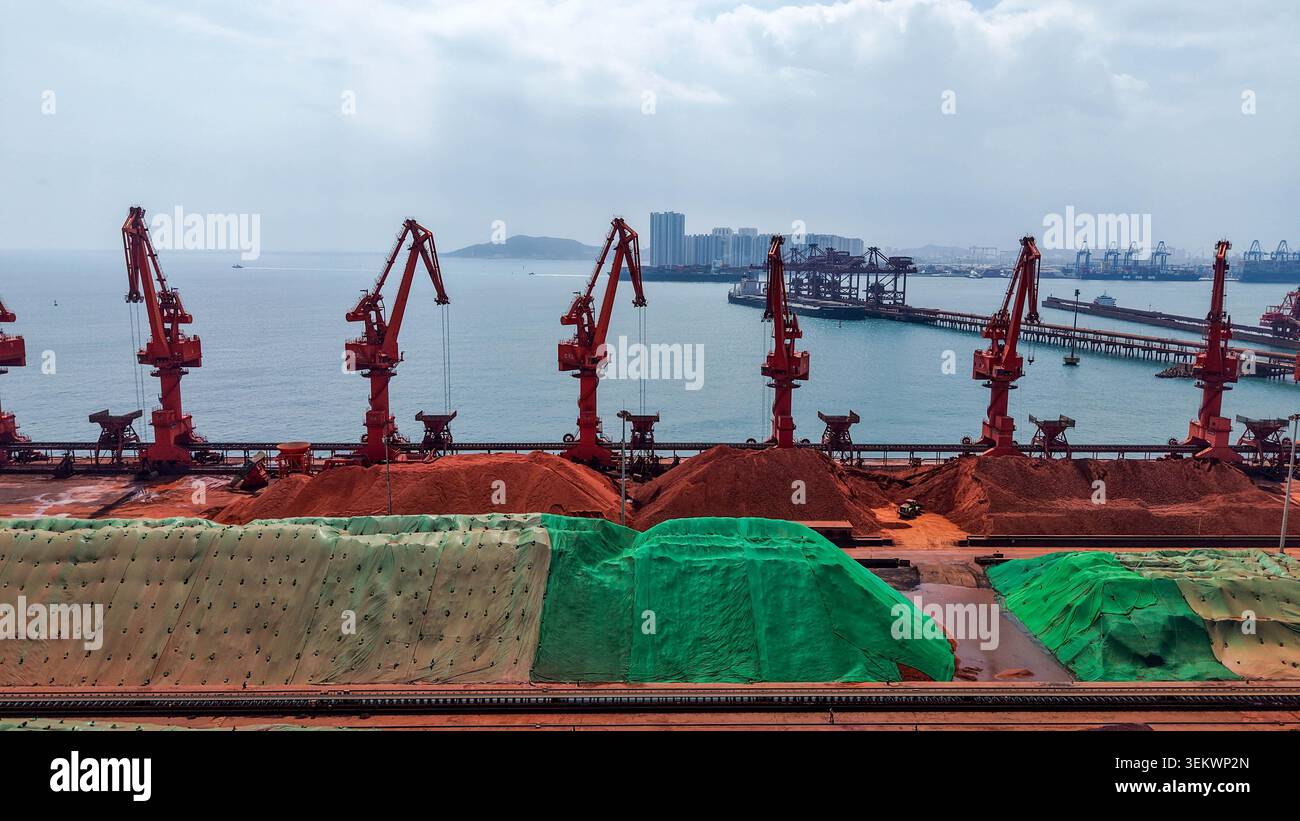 Engineering vehicles operate at the iron ore terminal of Qingdao Port ...