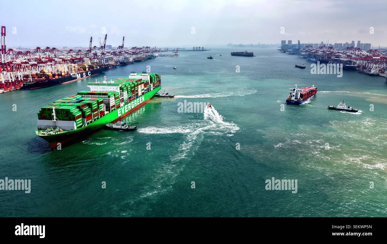 A cargo ship loaded with foreign trade containers docks at Qingdao Port ...