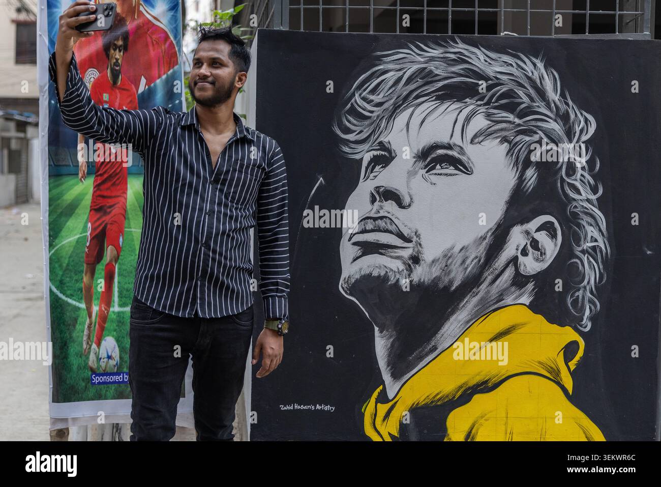 A man seen taking a selfie with a graffiti of famous football star ...