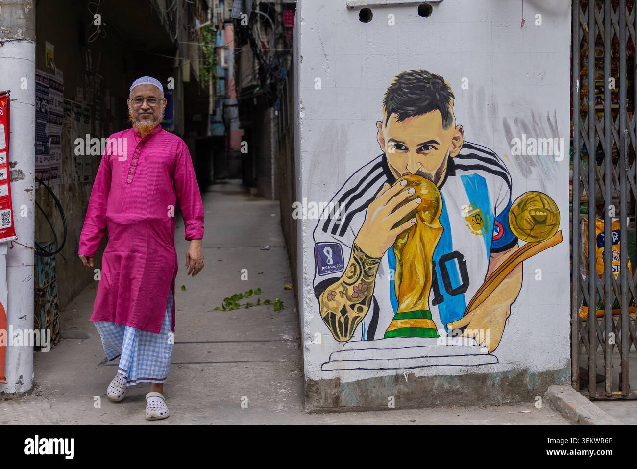 A man seen standing besides a graffiti of famous Argentine football ...