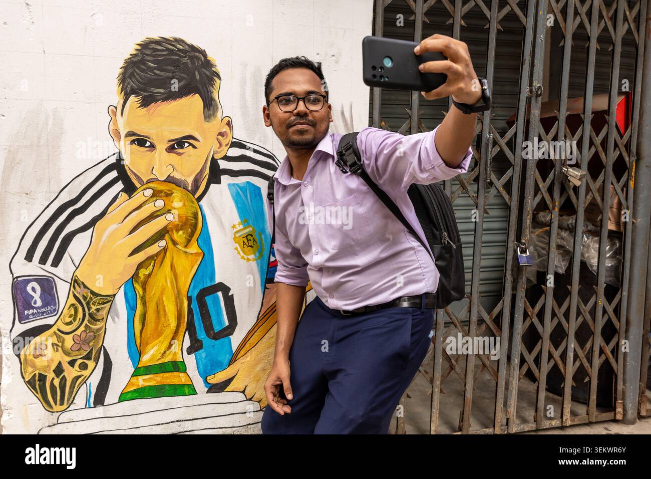 A man seen taking a selfie with a graffiti of famous Argentine football ...