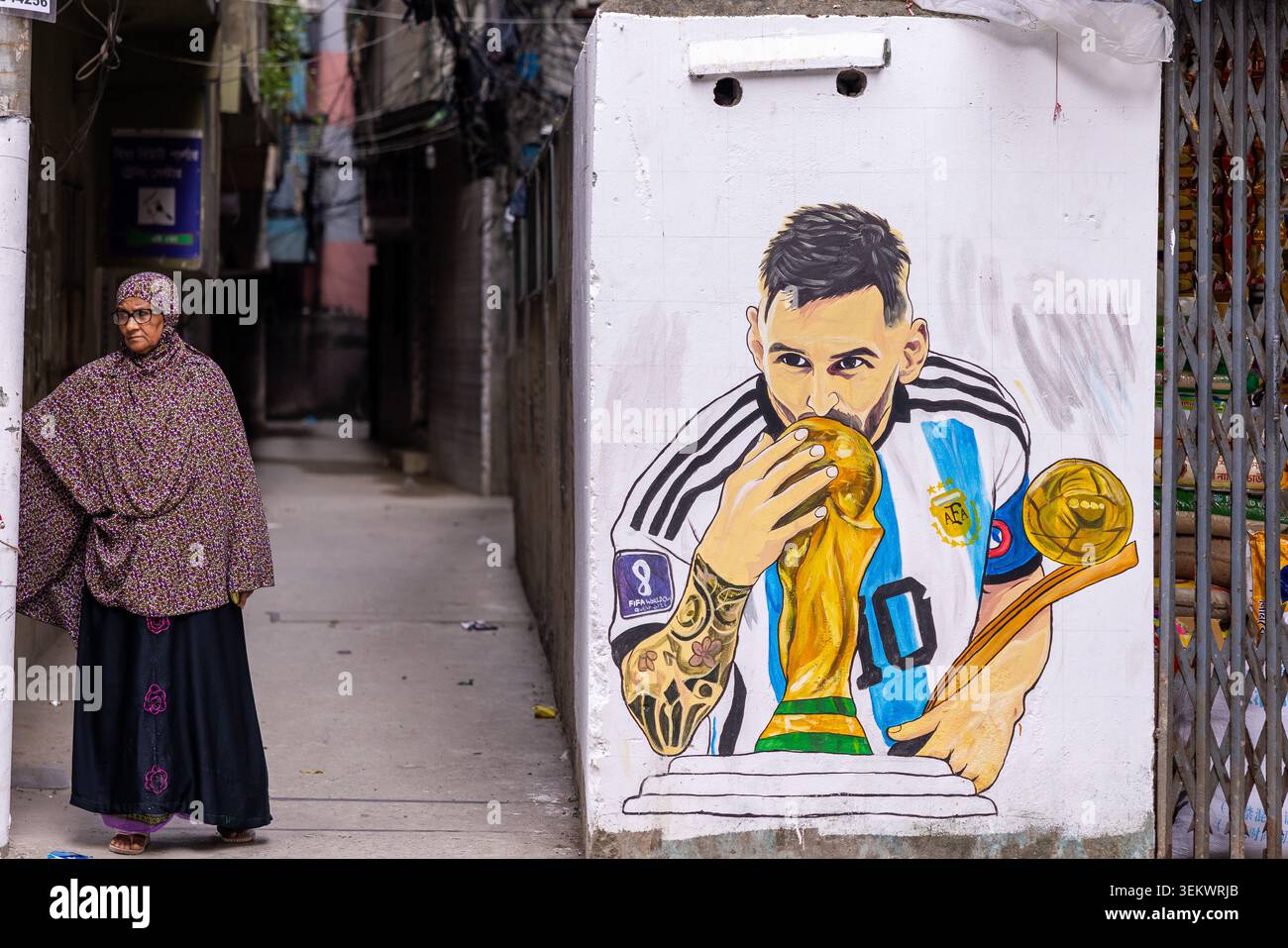 A women seen standing besides a graffiti of famous Argentine football ...