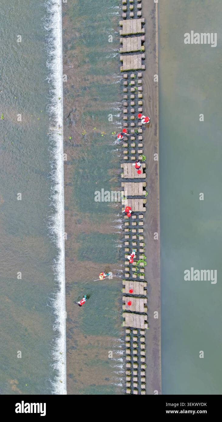 Party members and volunteers clean the Yong'an River in Xiandu County ...