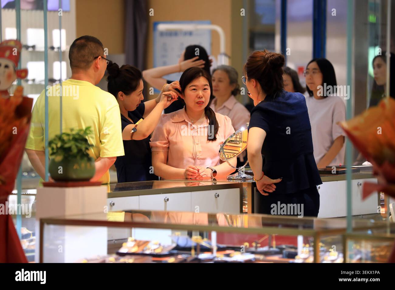 A consumer selects gold jewelry at a store in Huai'an, east China's ...