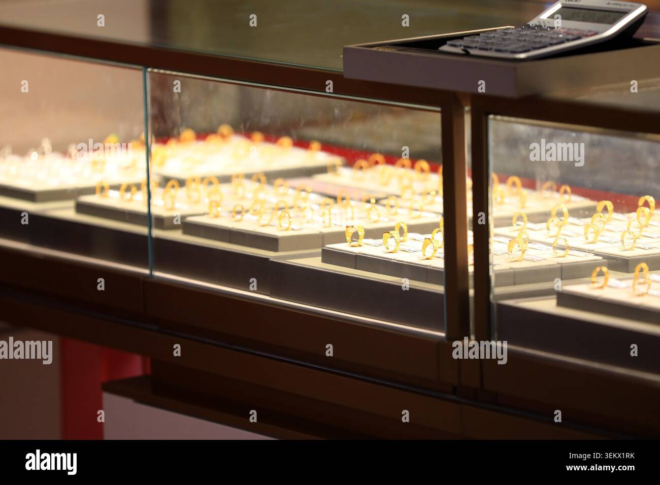A consumer selects gold jewelry at a store in Huai'an, east China's ...