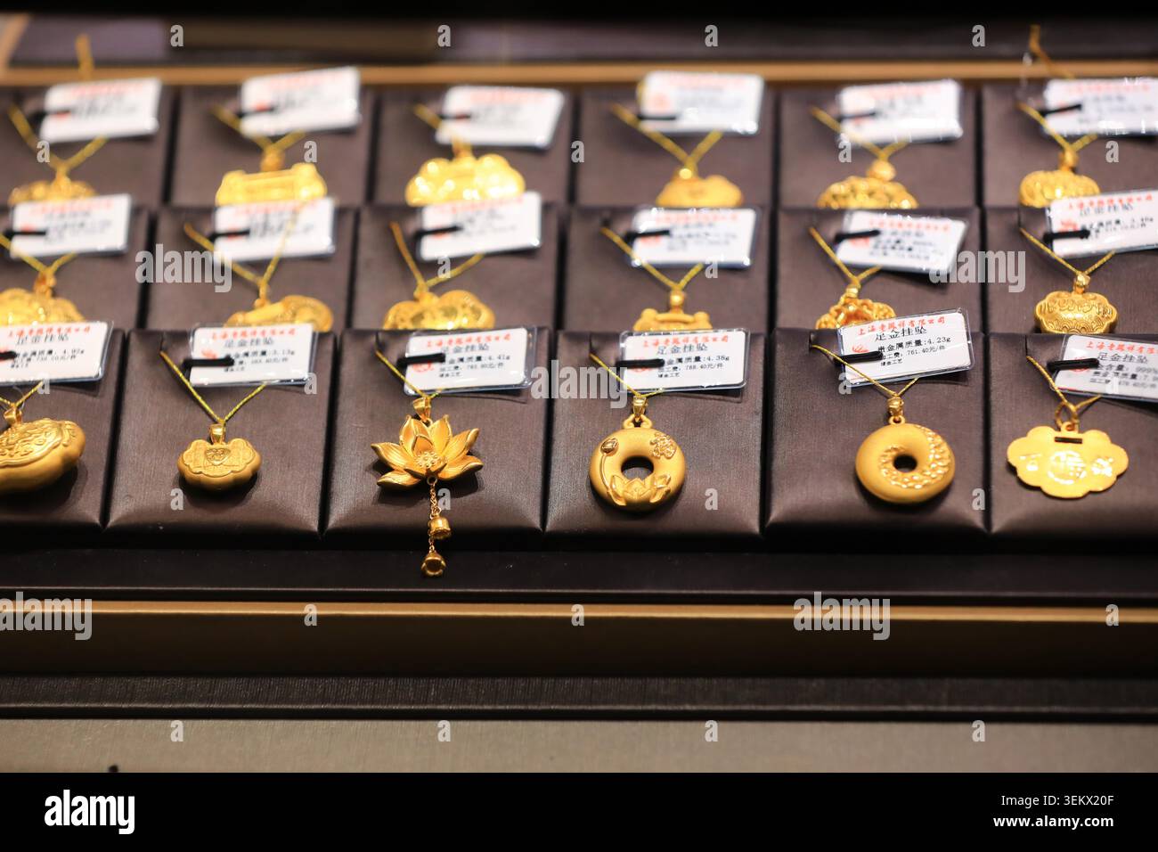 A consumer selects gold jewelry at a store in Huai'an, east China's ...