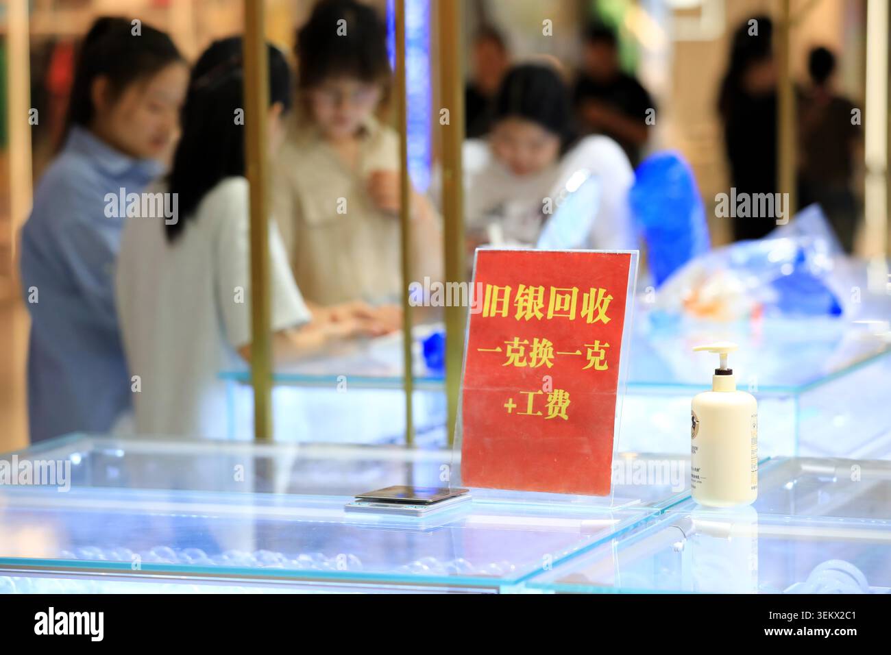 A consumer selects gold jewelry at a store in Huai'an, east China's ...