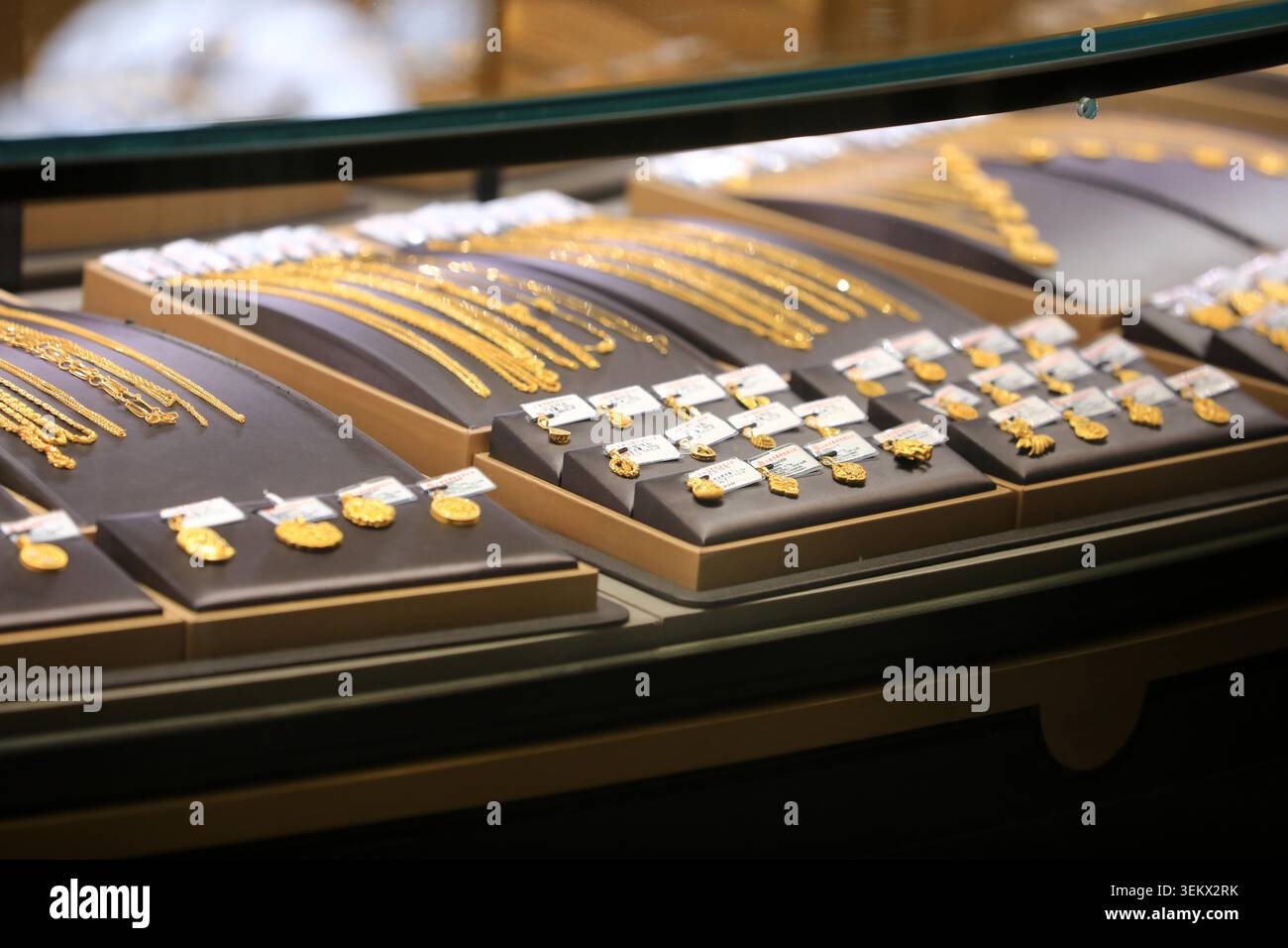 A consumer selects gold jewelry at a store in Huai'an, east China's ...