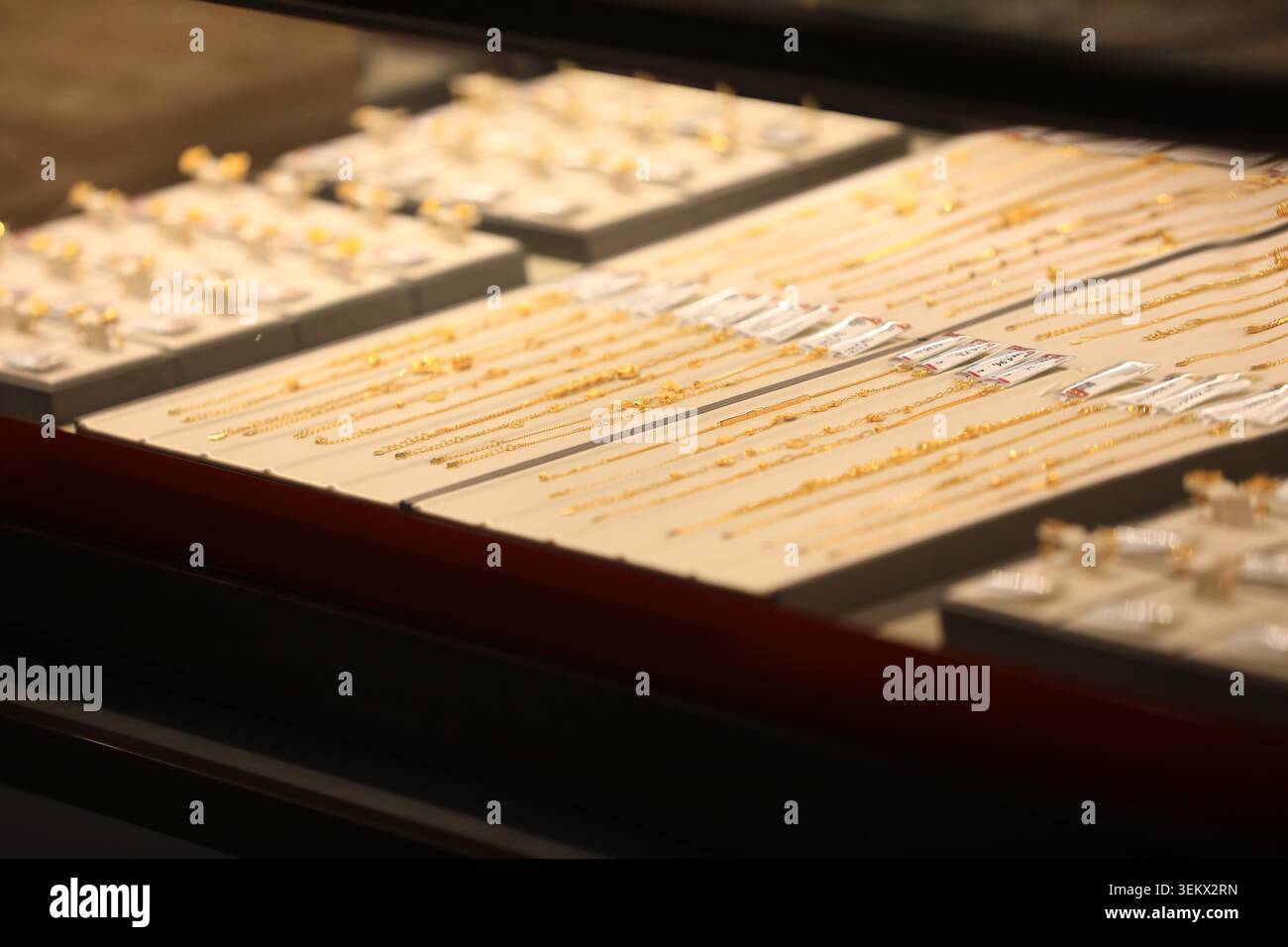A consumer selects gold jewelry at a store in Huai'an, east China's ...