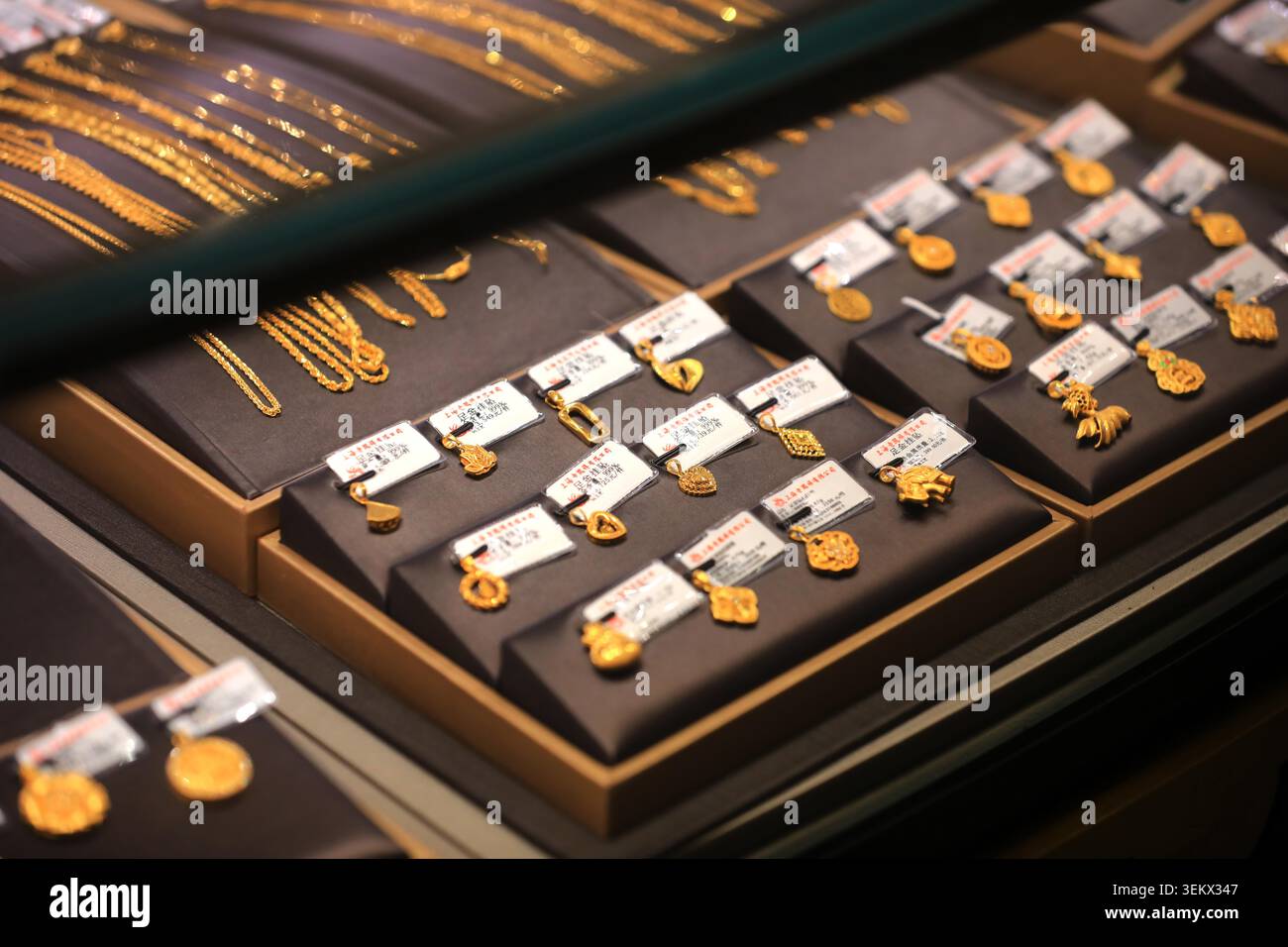 A consumer selects gold jewelry at a store in Huai'an, east China's ...