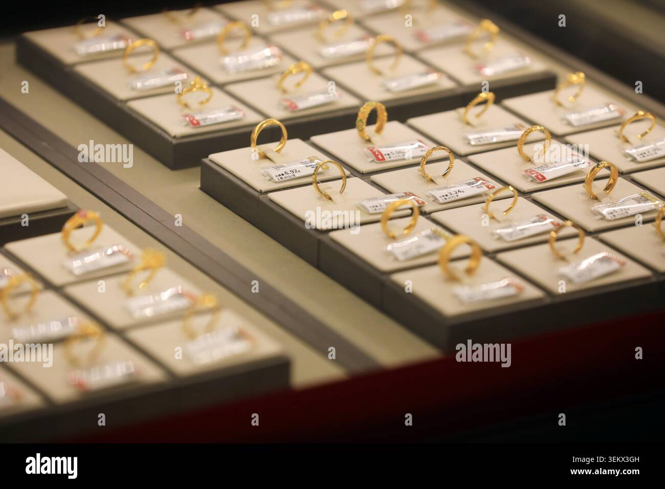 A consumer selects gold jewelry at a store in Huai'an, east China's ...