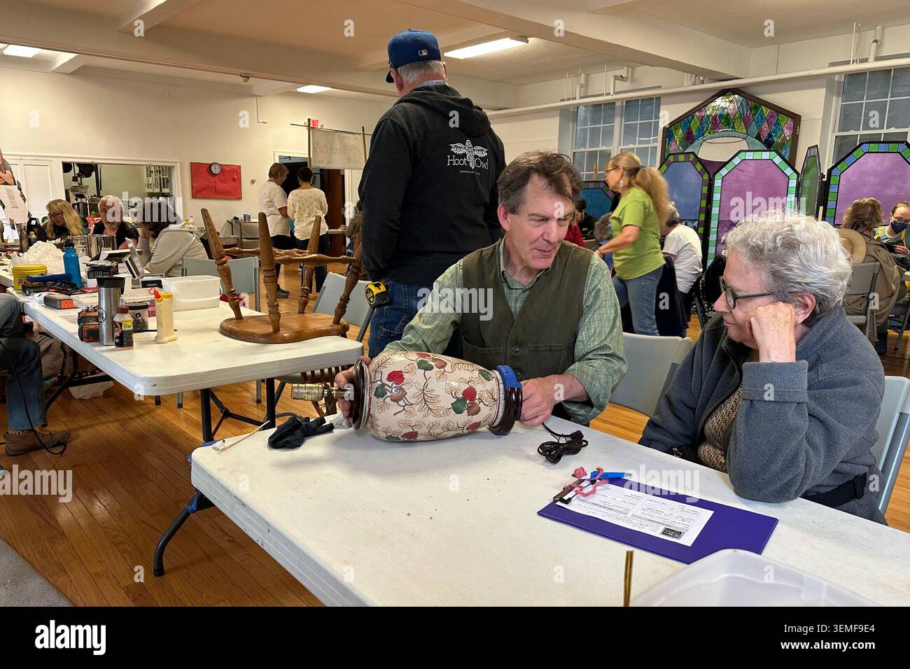 Wood repair coach Erik Hoover helps fix a lamp at a Repair Café in New ...