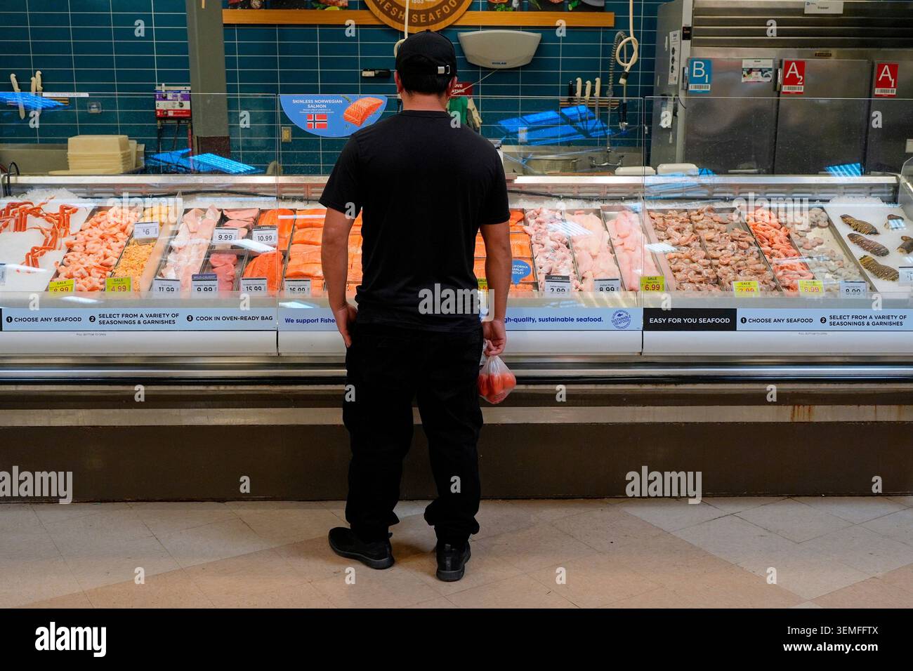 FILE - A person looks at the fresh fish at a grocery store Monday, May ...